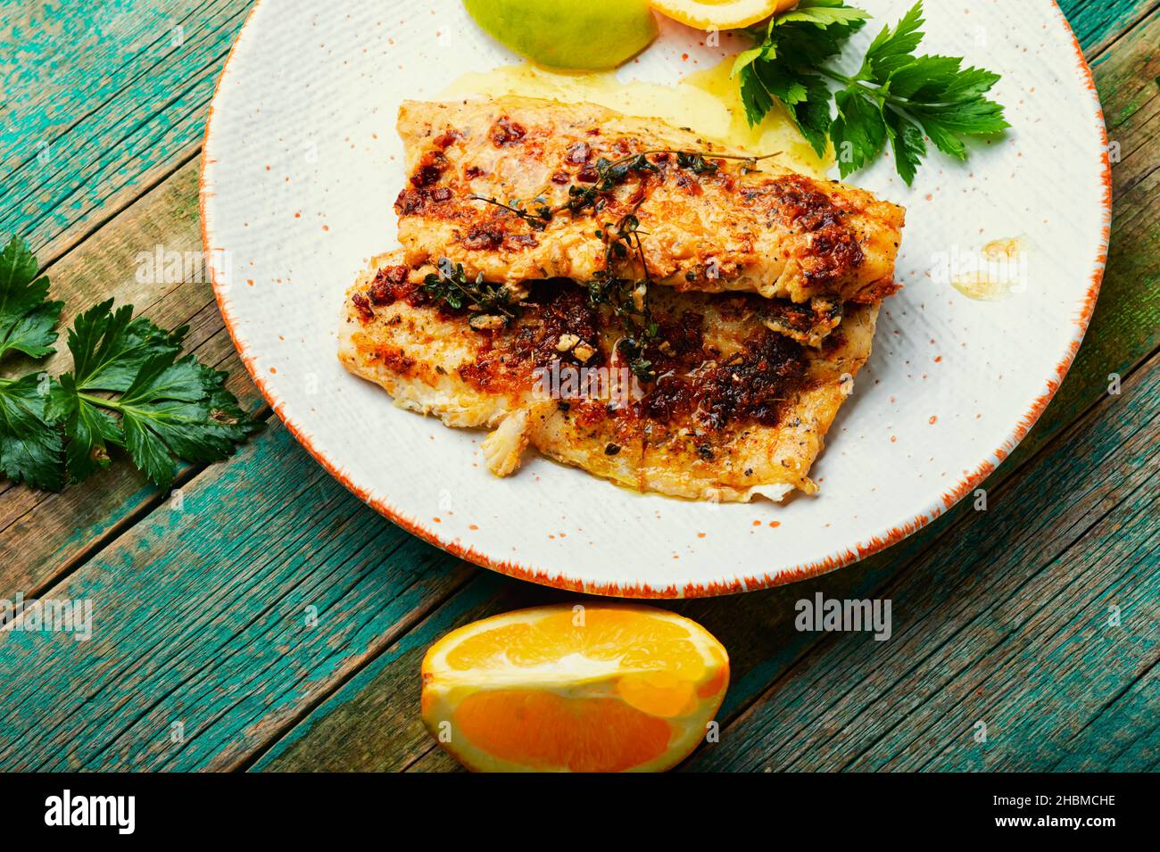 Fish fillet fried in orange oil, fish dish Stock Photo - Alamy