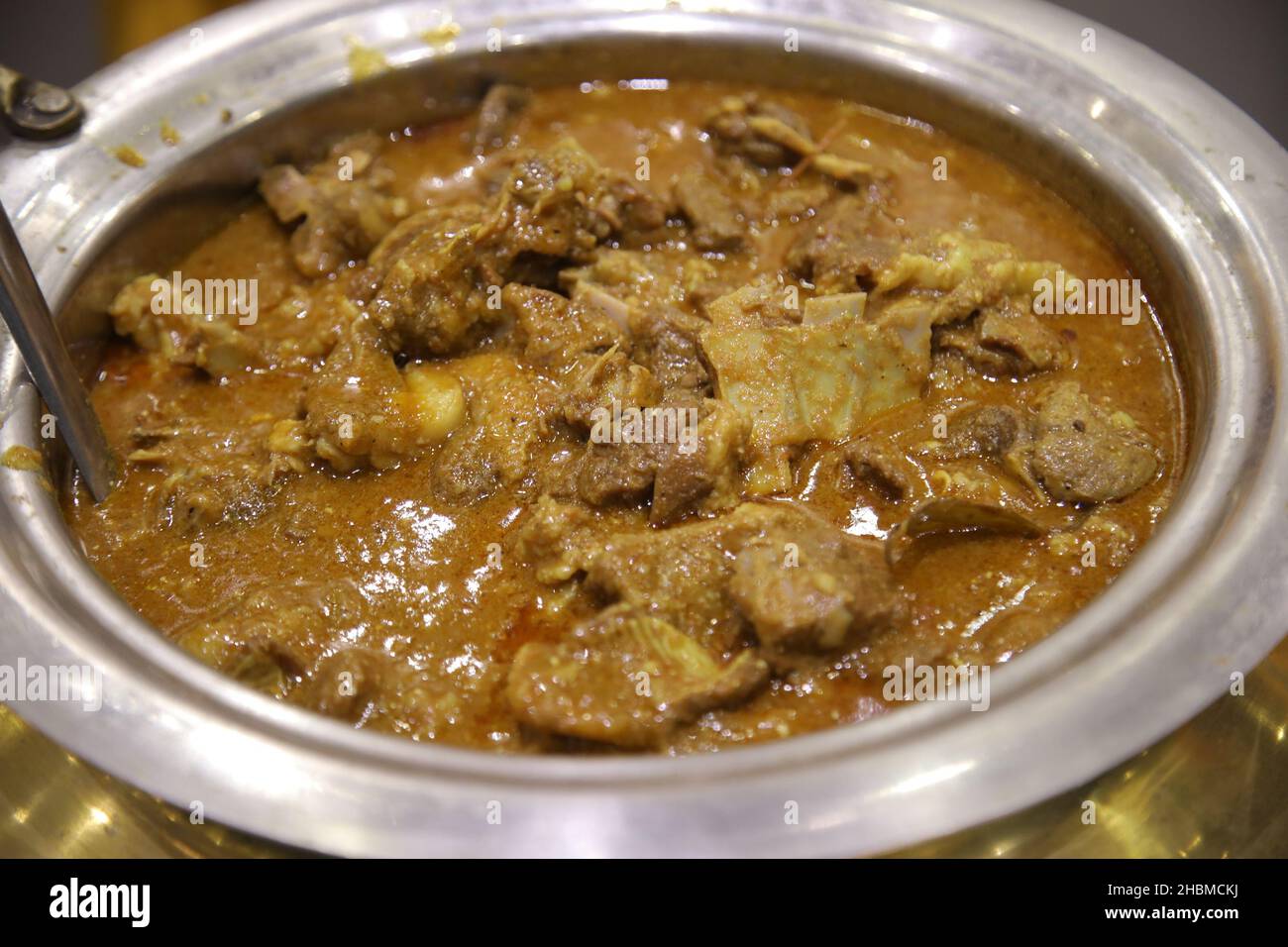 Close-up shot of the spicy mutton gravy served in an Indian wedding ...