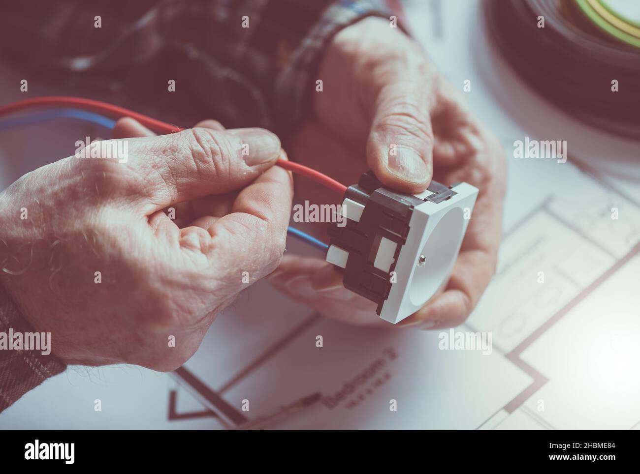 Electrician hands connecting a wire into a power socket Stock Photo - Alamy