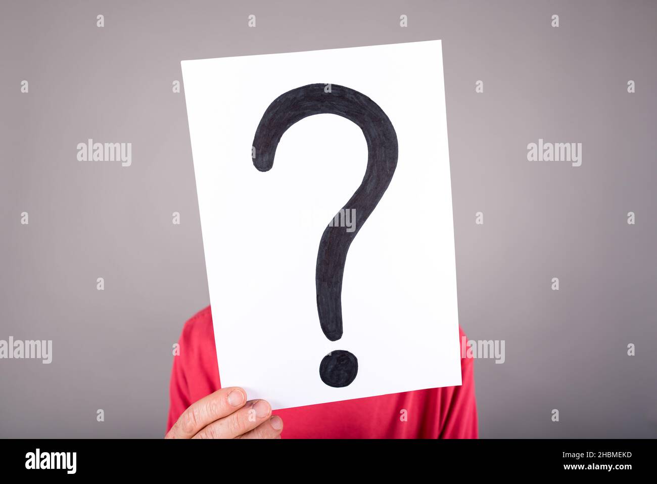 Man holding a paper with a question mark Stock Photo - Alamy