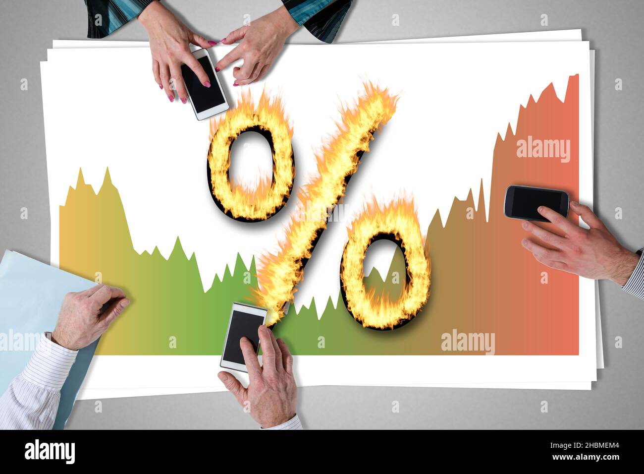 Interest rates concept placed on a desk with hands using smartphones ...