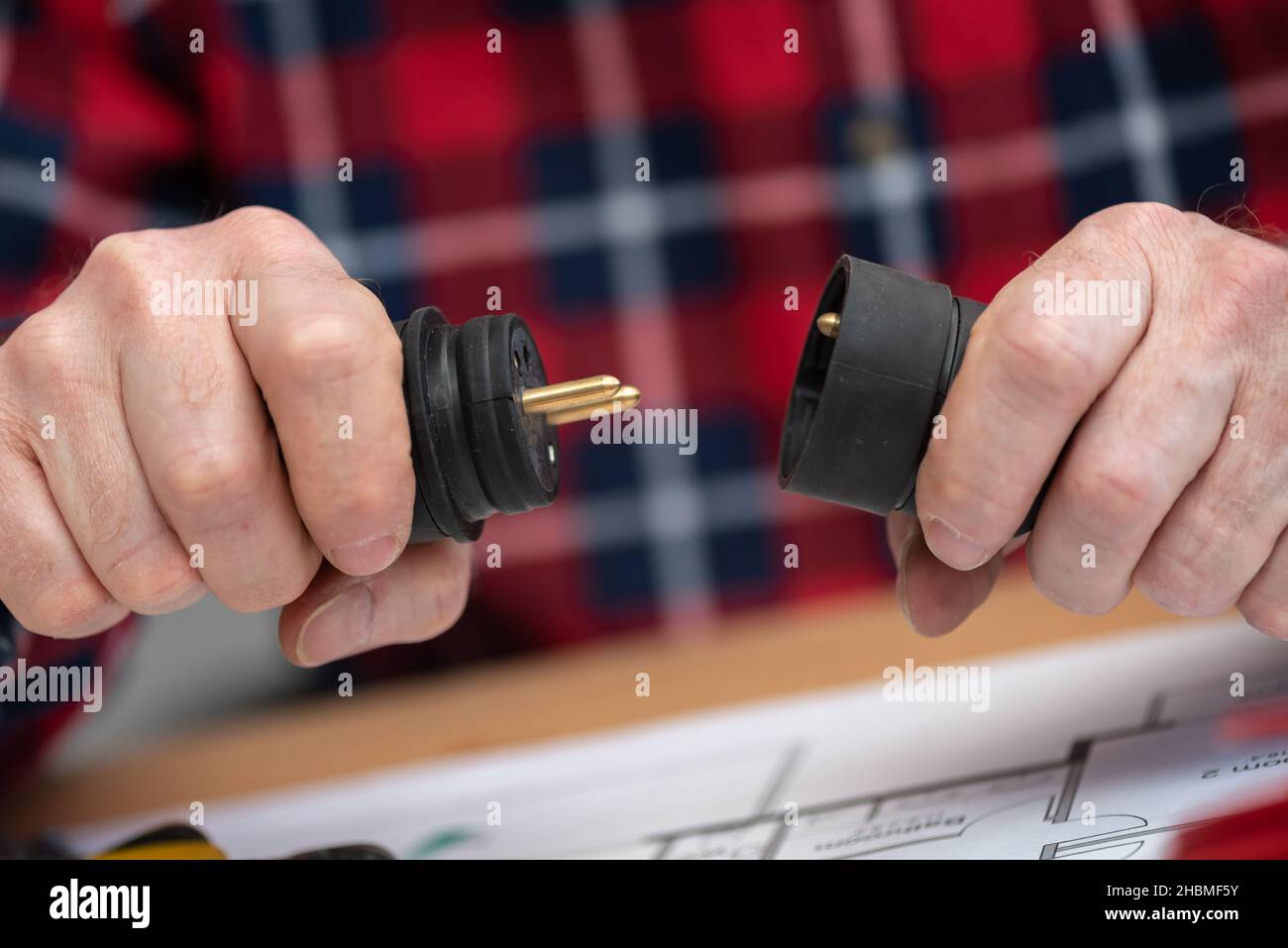 Electrician hands holding electrical plugs Stock Photo - Alamy