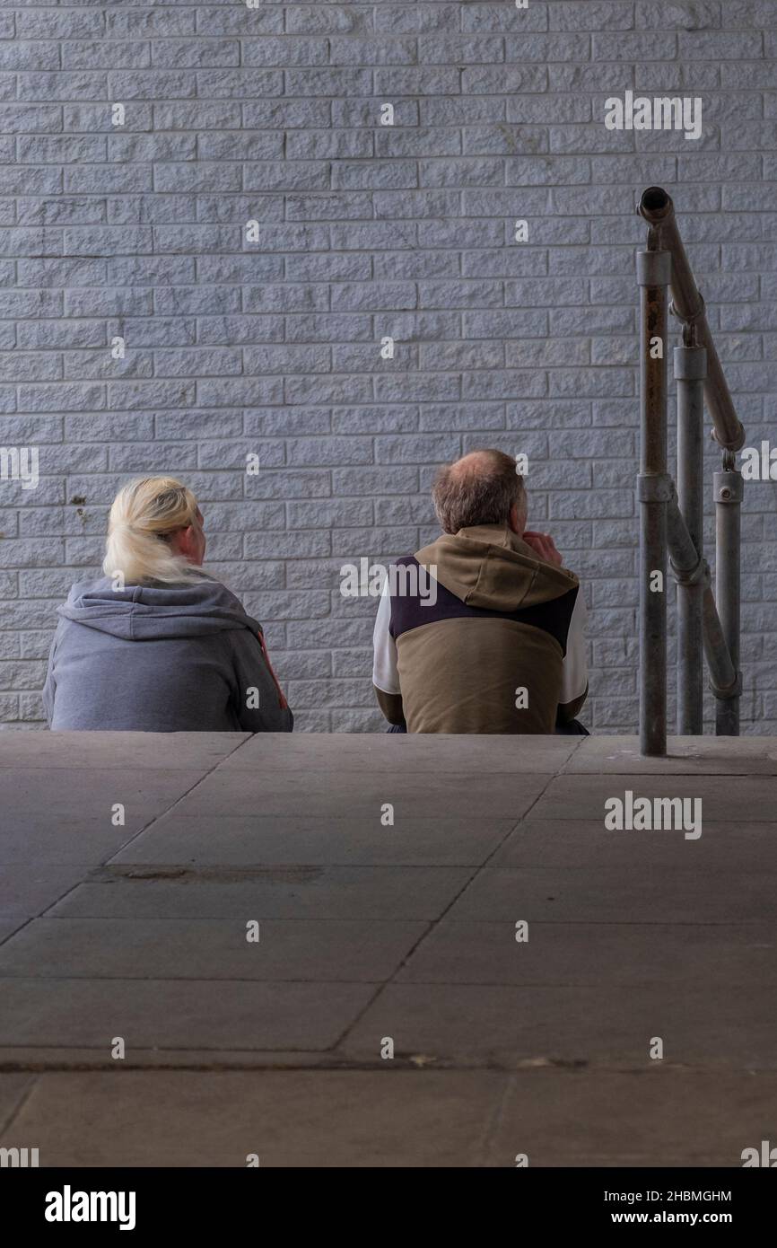 Rear view of two people sitting on steps Stock Photo - Alamy