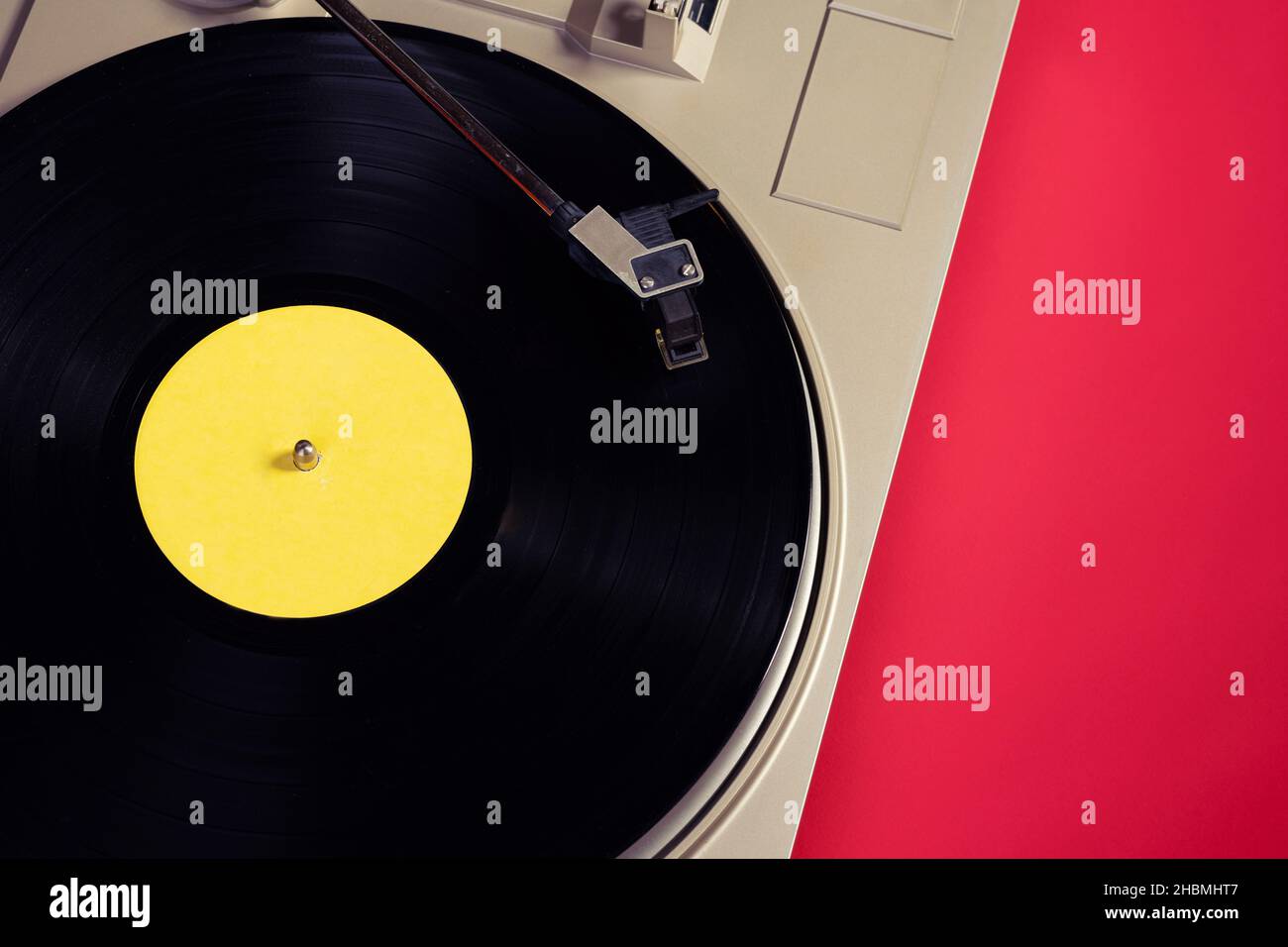 Gramophone with a vinyl record on a red table, top view and copy space ...