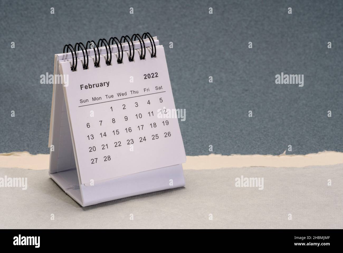 February 2022 - spiral desktop calendar against abstract paper ...