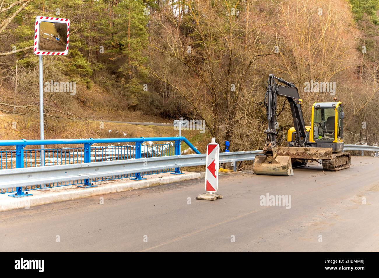 Excavator adjusts the terrain around the new bridge. Finishing work on ...