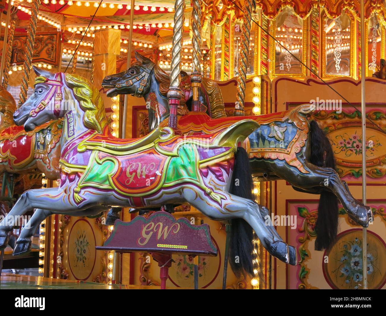 Traditional fairground ride with painted horses on a merry-go-round for ...