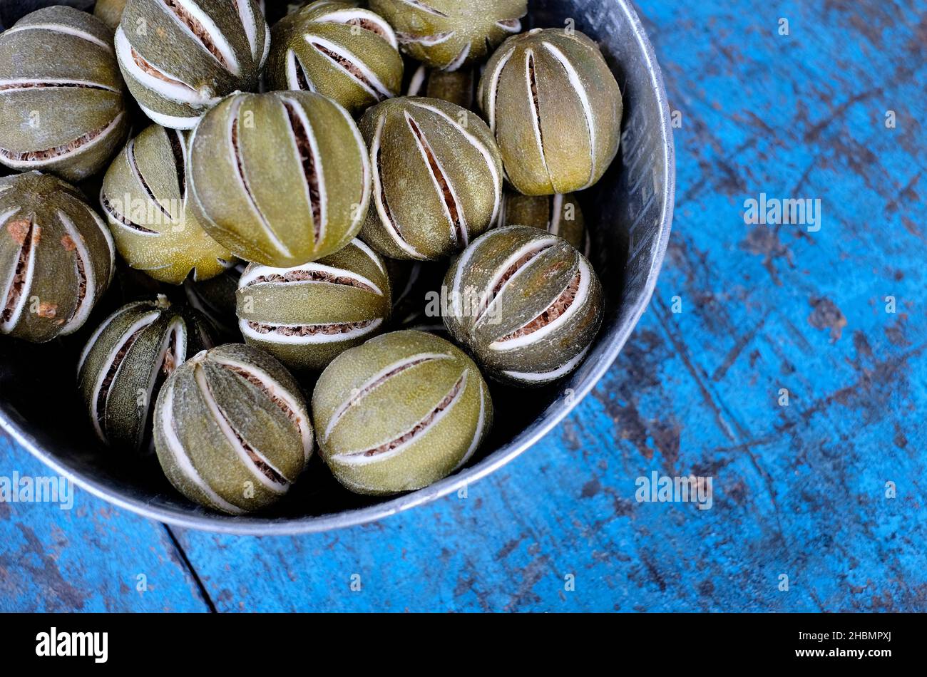 dried split limes in metal bowl on old blue painted table top, norfolk ...