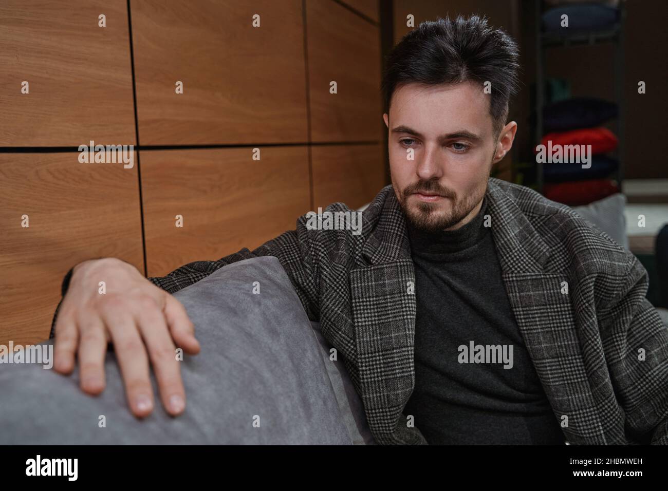 Serious thoughtful male shopper sitting on couch Stock Photo - Alamy