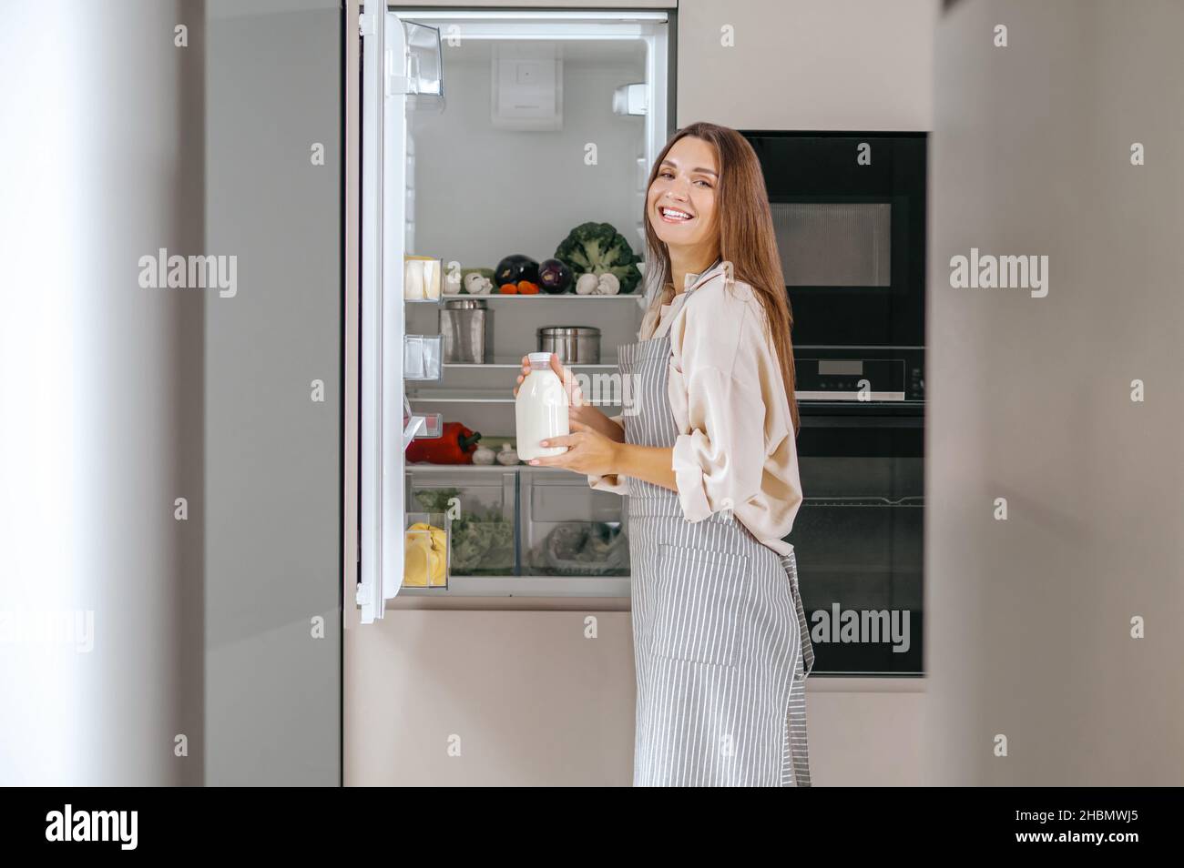Young woman taking food from the fridge Stock Photo - Alamy