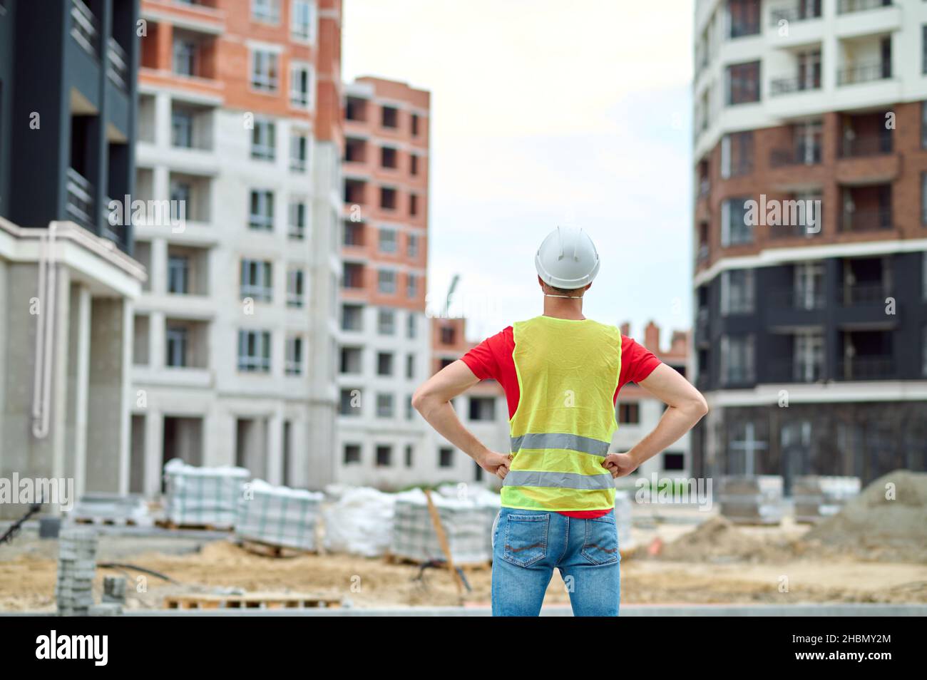 Back view of man looking at construction site Stock Photo - Alamy