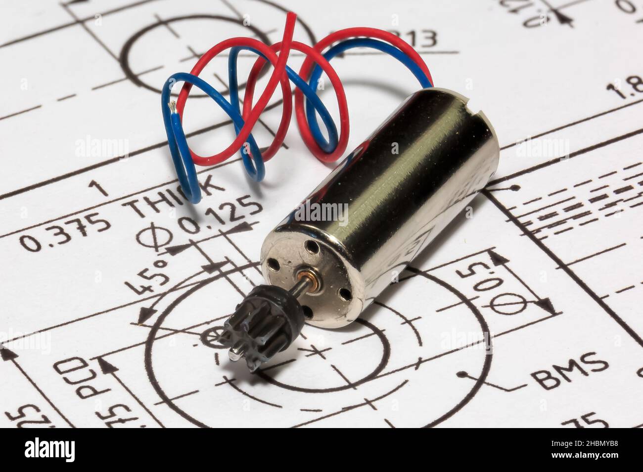 Closeup on a miniature electric motor fitted with a nylon gear placed ...