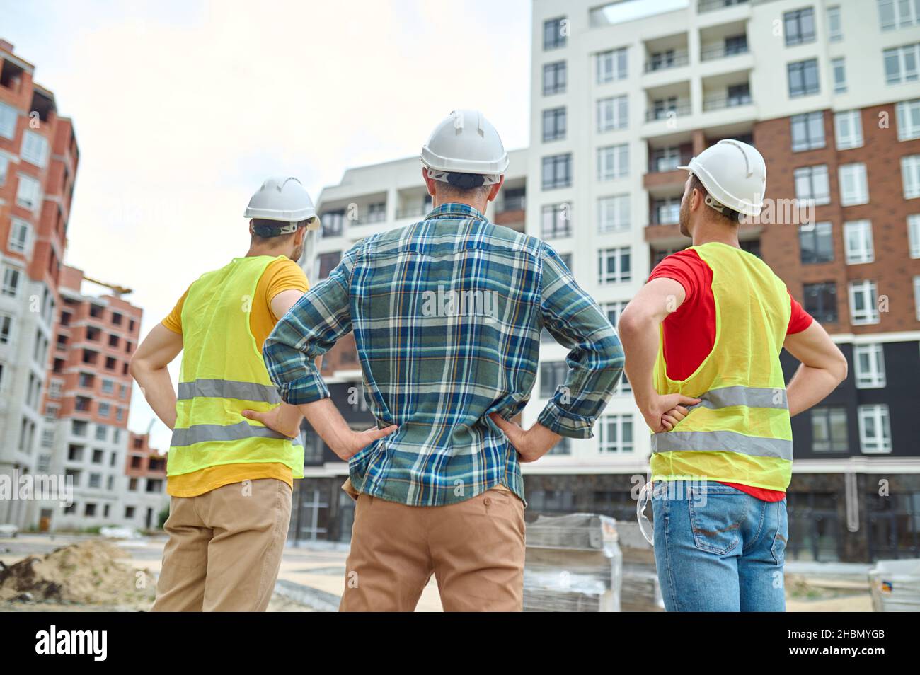 Back view of three men standing at construction site Stock Photo - Alamy