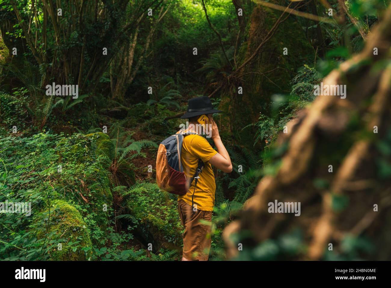 A Caucasian male wearing yellow outfit and a backpack walking in a ...
