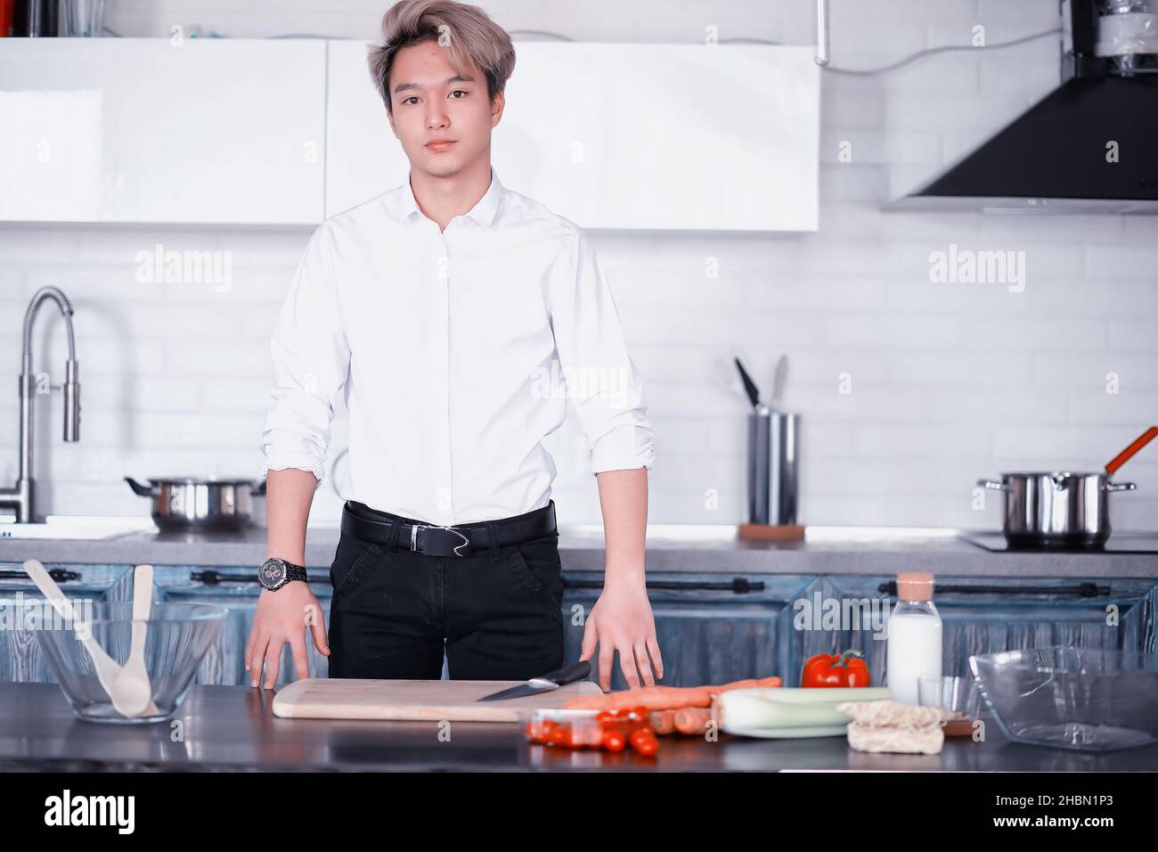 A young Asian cook in the kitchen prepares food in a cook suit Stock ...