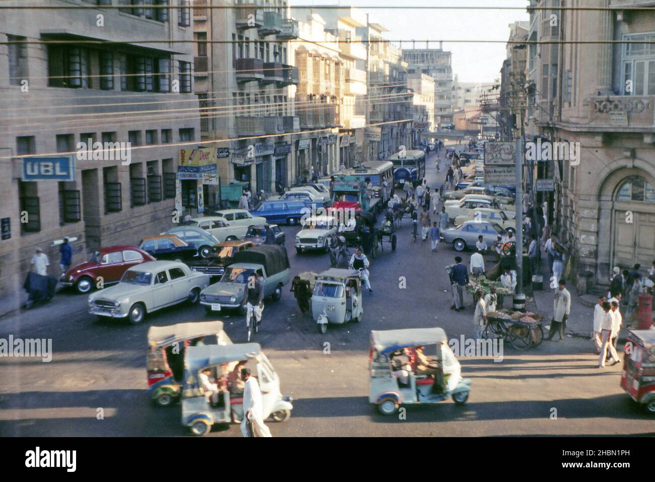 Busy street junction with tuk-tuks, cars, buses, bicycles, and horse ...