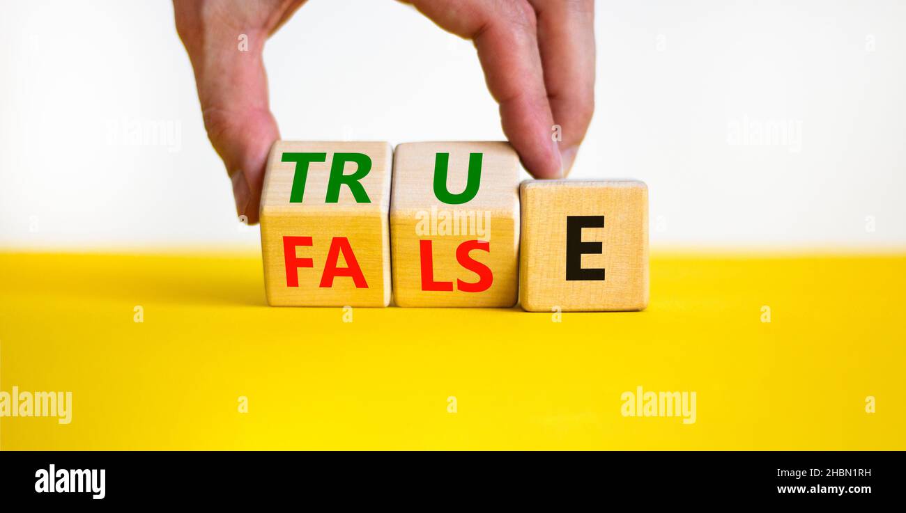 False or true symbol. Businessman turns wooden cubes and changes the ...