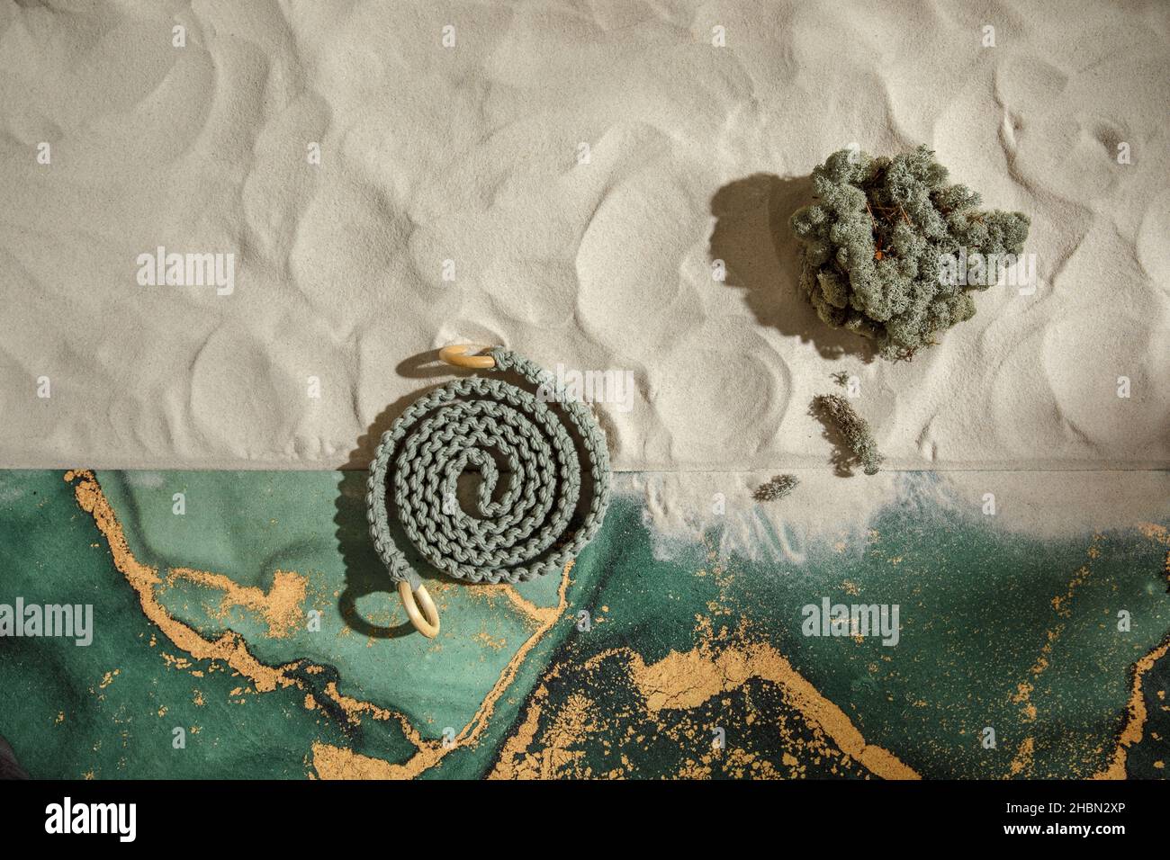 Unrolled moss green yoga mat, rope for stretching and dried moss on ...