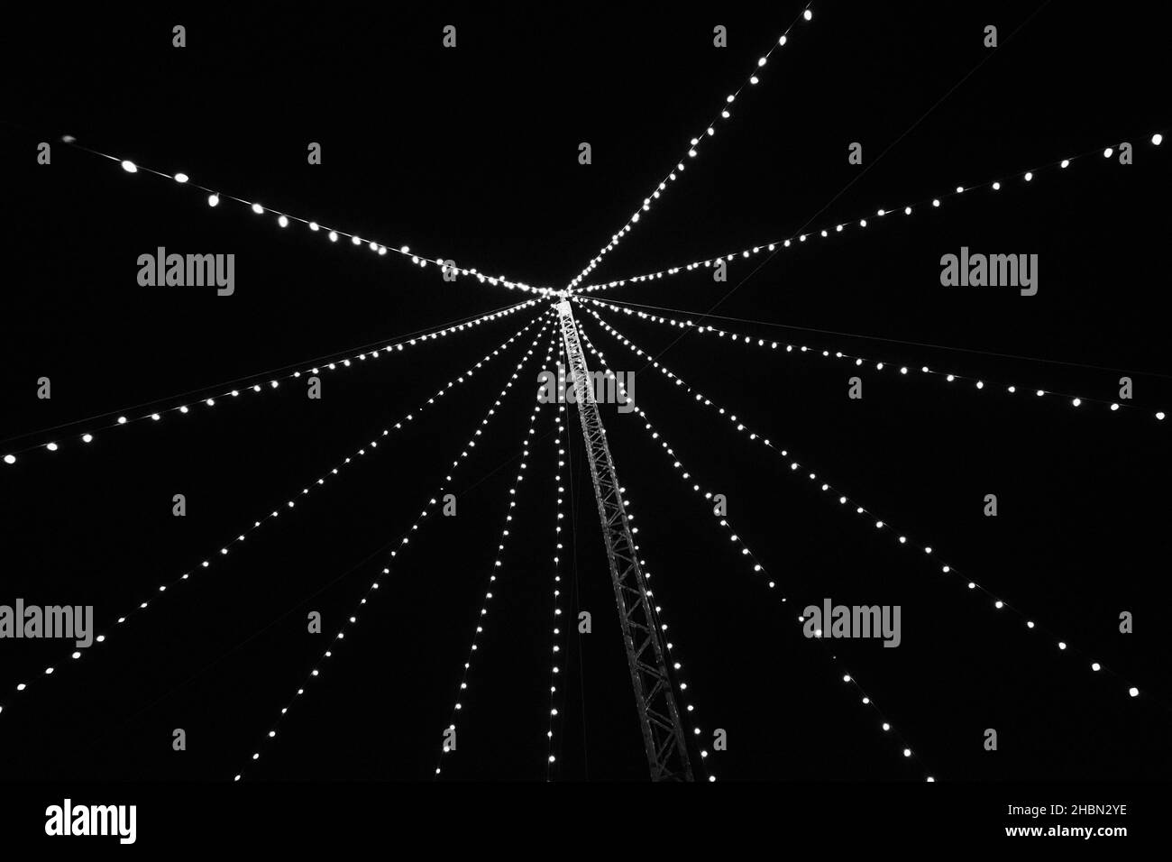 Christmas strings lights attached to the top of a tower, black and ...