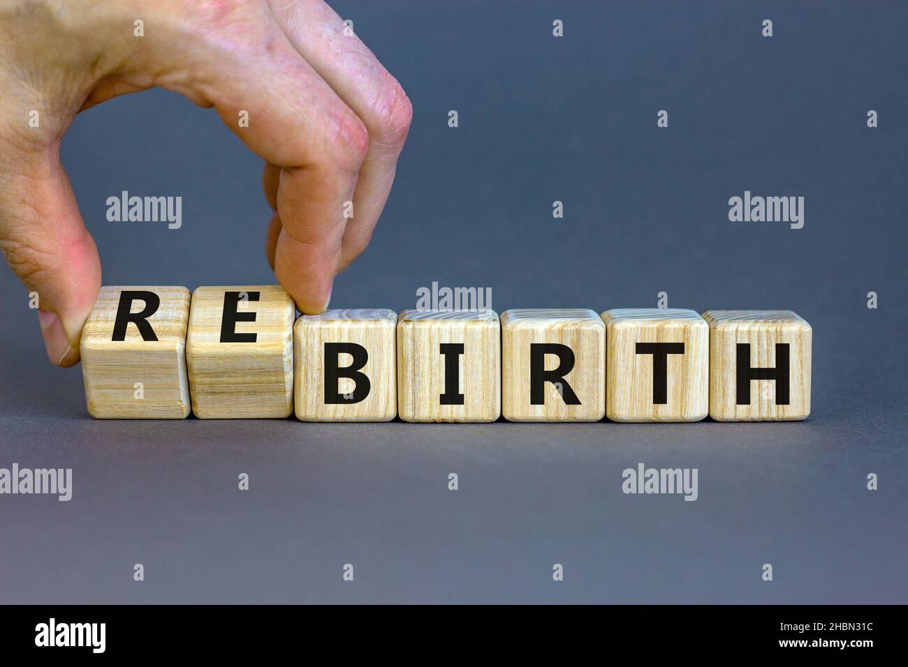 Birth or rebirth symbol. Businessman turns wooden cubes and changes the ...