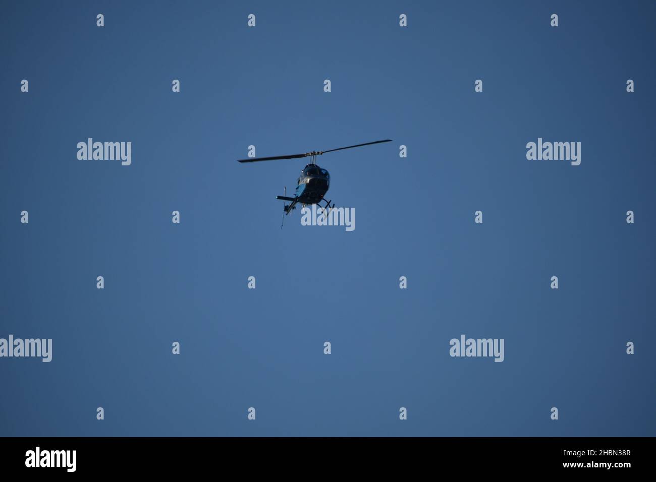 Frontal view of dark blue helicopter approach in flight Stock Photo - Alamy