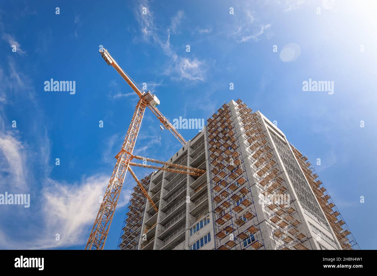 Construction of houses and hoist crane Stock Photo - Alamy