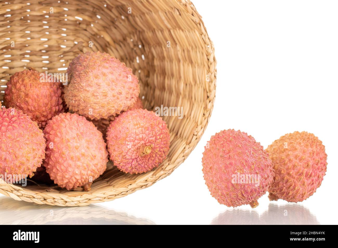 Several ripe organic litchi fruit with straw dishes, close-up, isolated ...