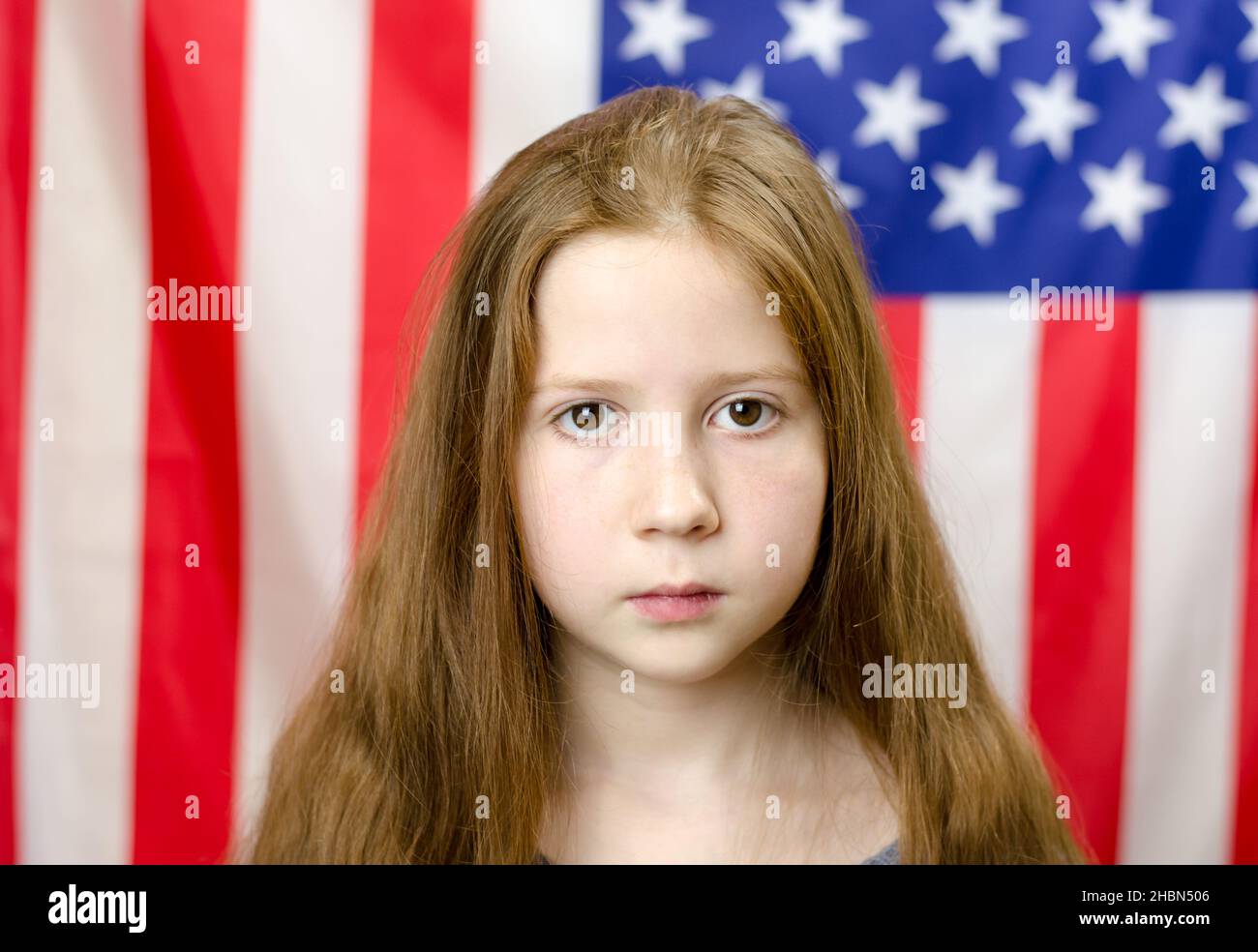 Sad red-haired girl looks at the camera. Girl on the background of the ...