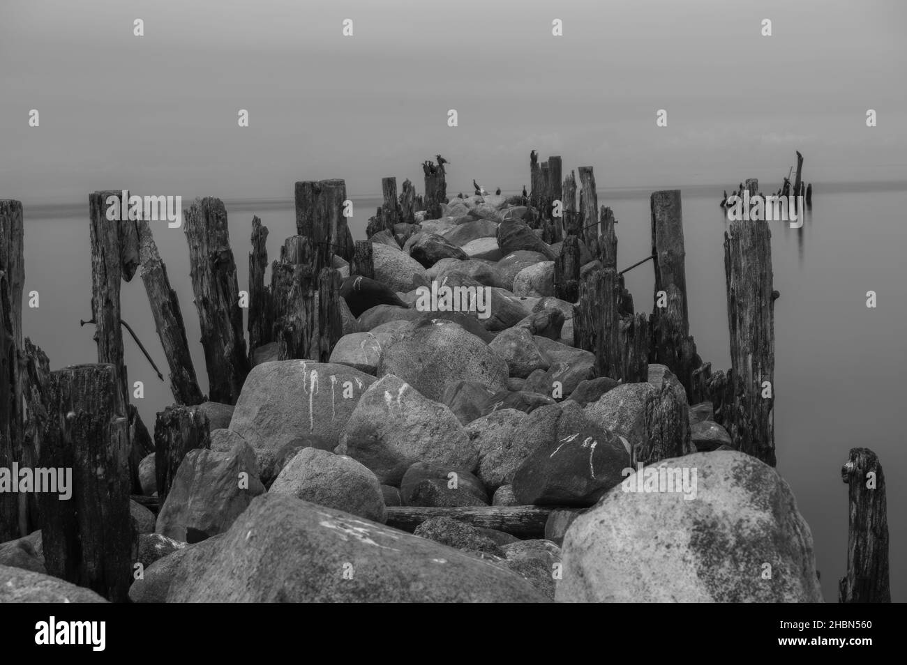 an old pier made of stones and wooden legs is left with metal screeds ...
