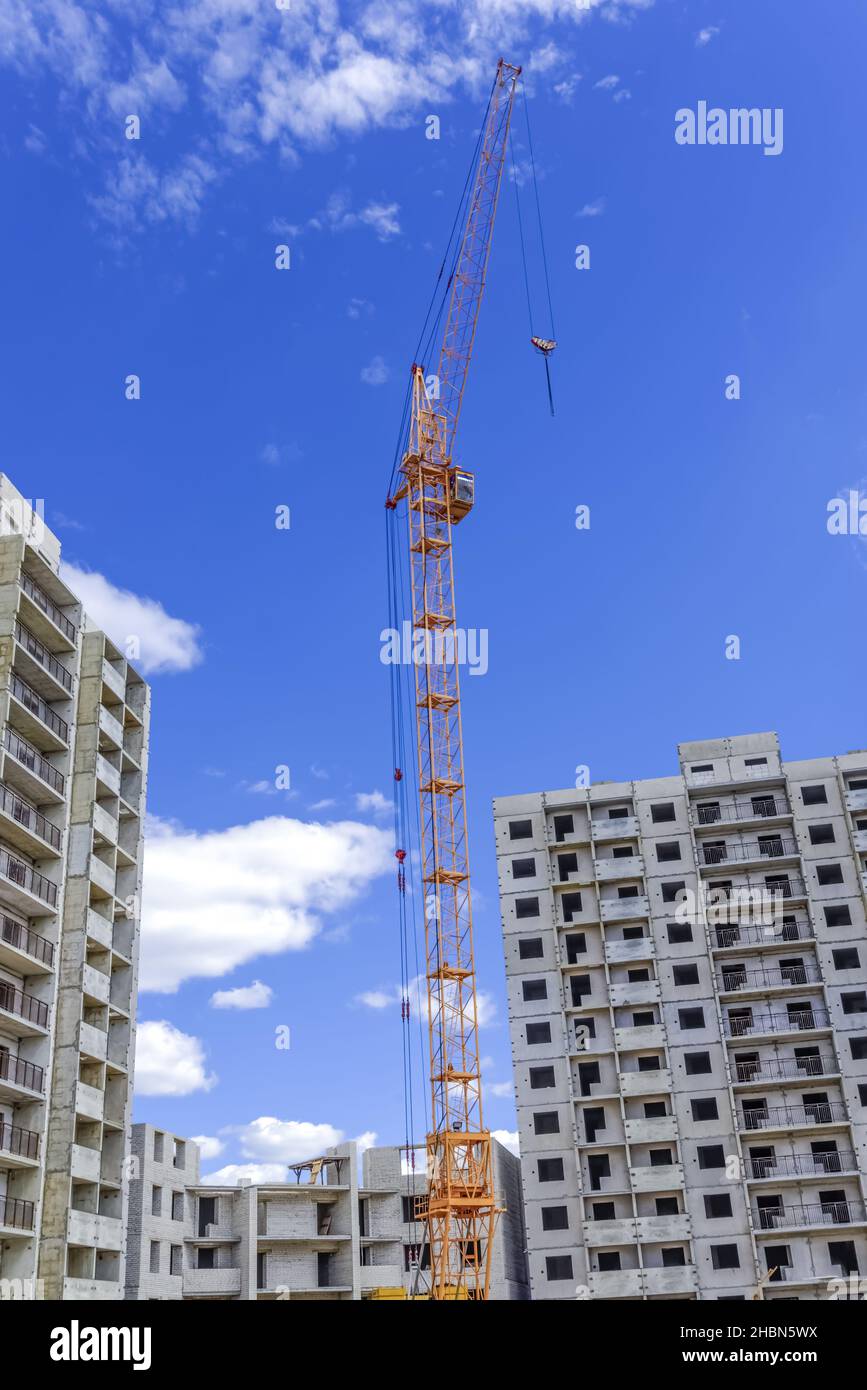 Building multistorey houses and hoisting tower cranes Stock Photo - Alamy