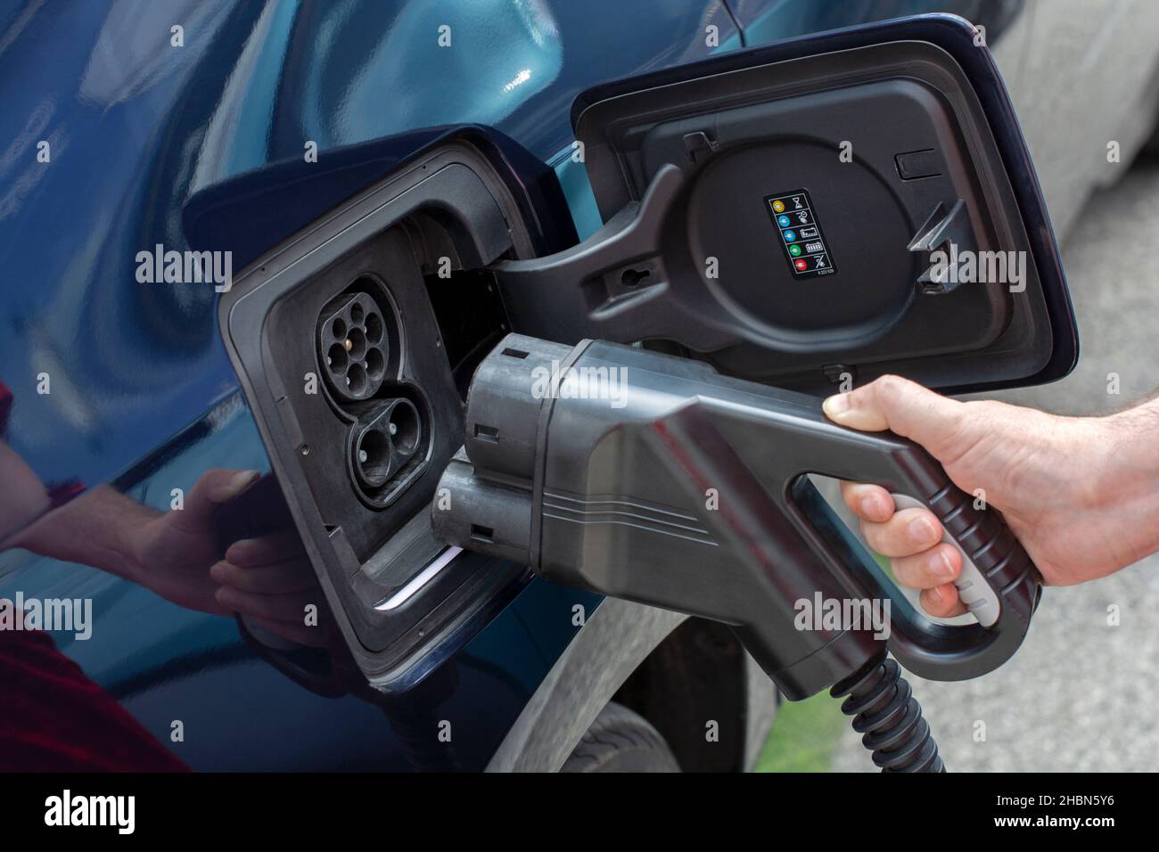 Human hand is holding electric car charging Stock Photo - Alamy