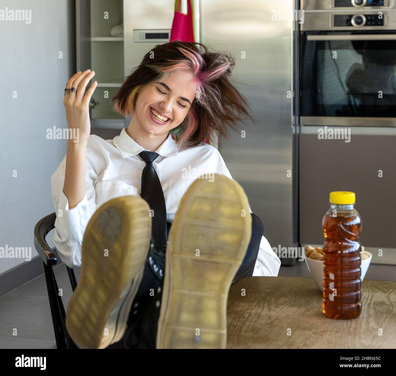 happy woman shaking her head from side to side, reclining in her chair ...