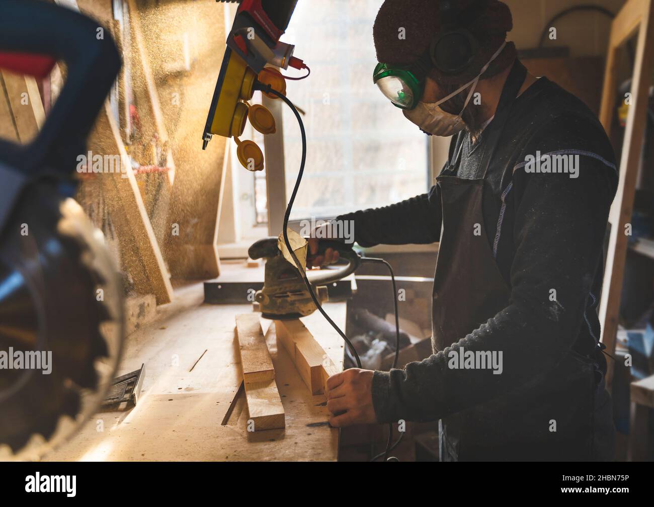 Man working with wood in workshop using sanding machine Stock Photo - Alamy