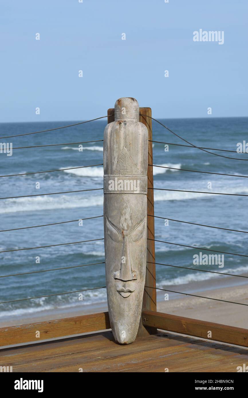 Close-up Tiki statue with blue ocean backdrop Stock Photo - Alamy
