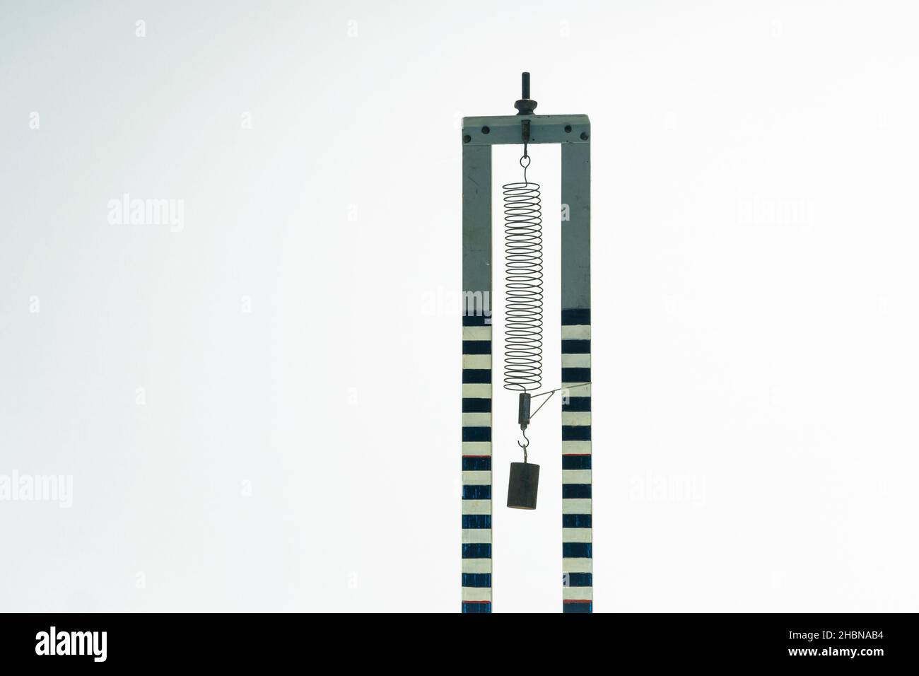 Weight hangs from a metal spring. Used for a vibration experiment or to ...