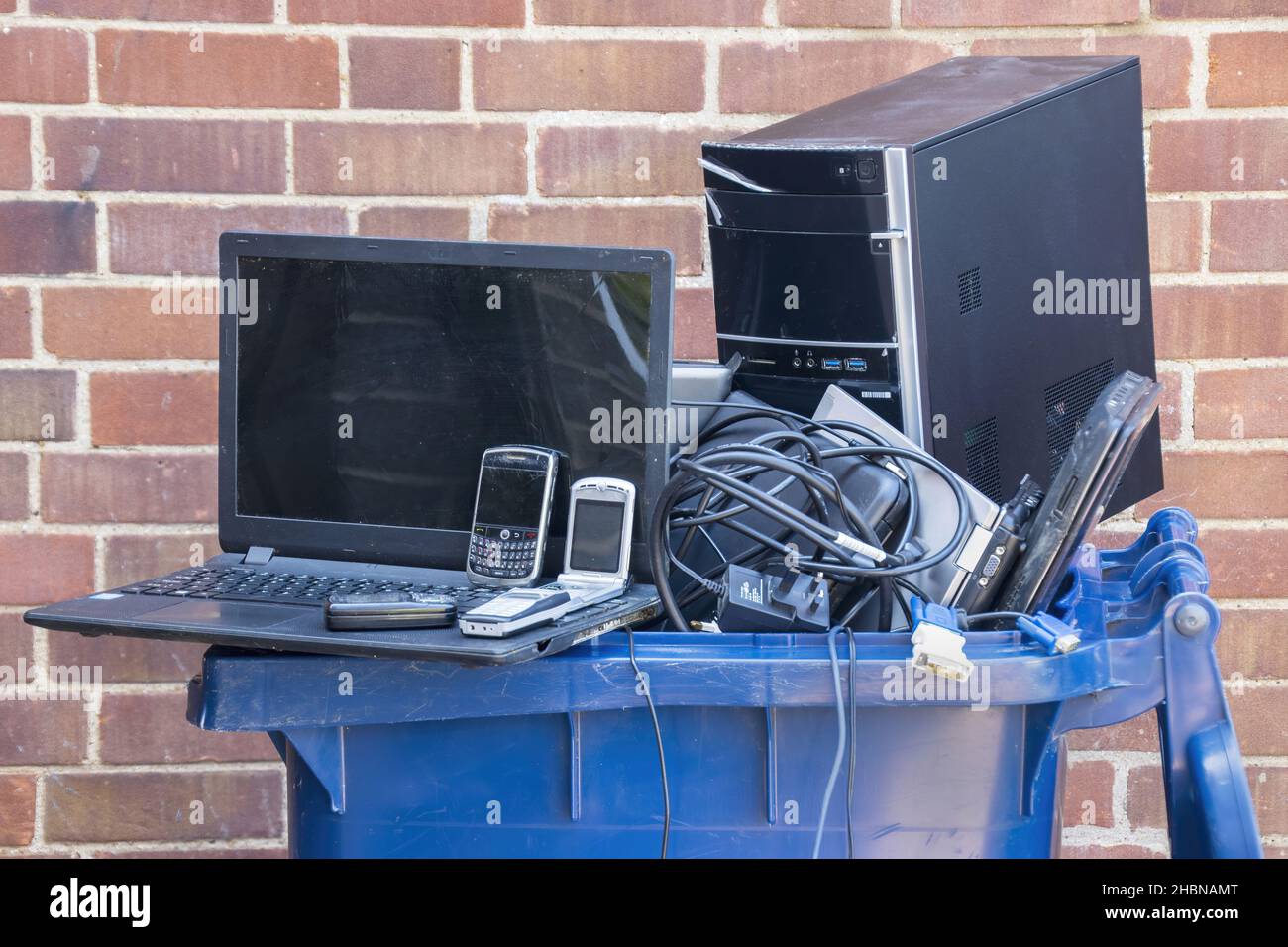 Old computer hardware and mobile devices put into a recycling container ...