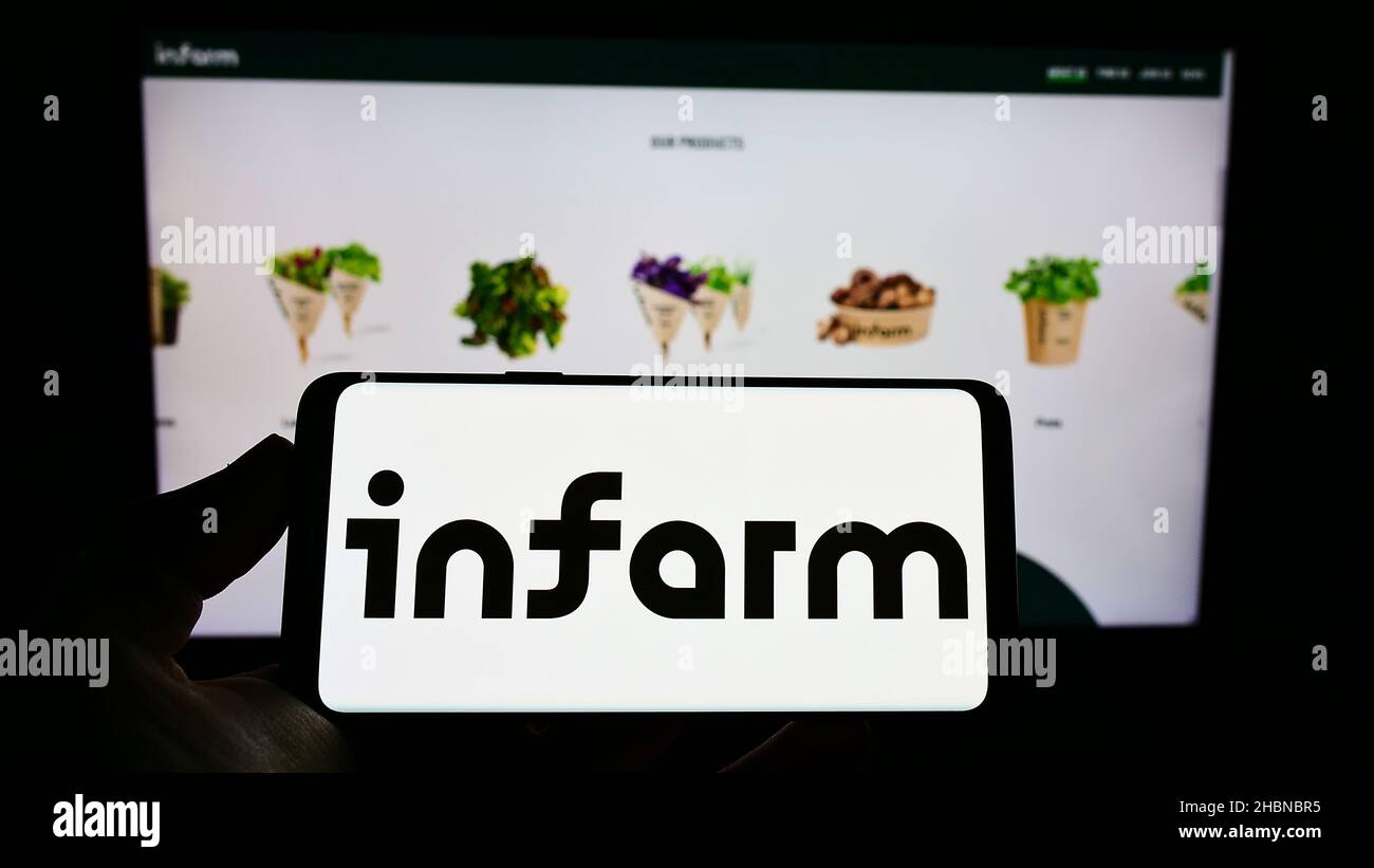 Person holding mobile phone with logo of German company infarm - Indoor ...