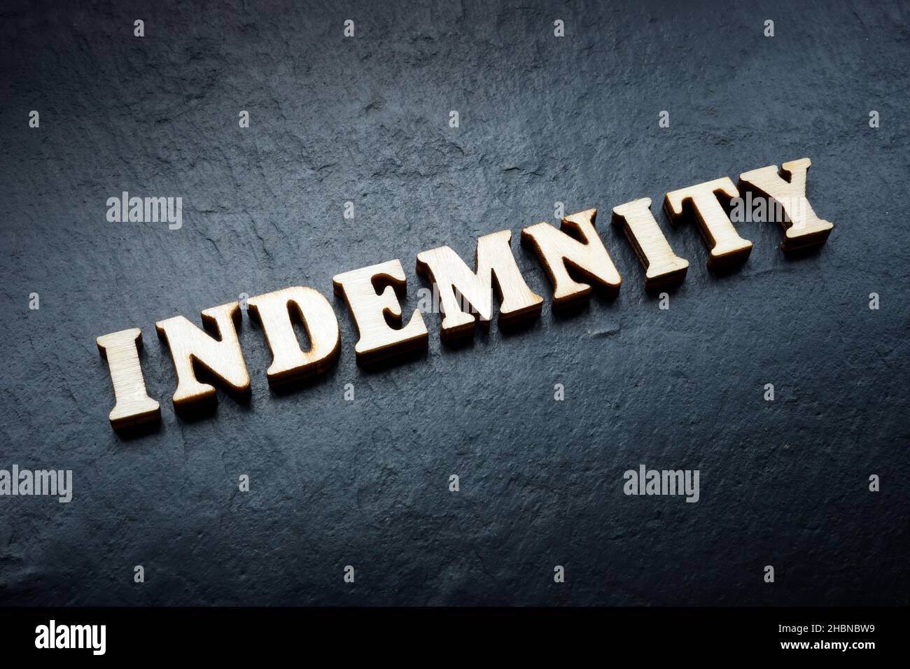 Word indemnity from wooden letters on the rock Stock Photo - Alamy