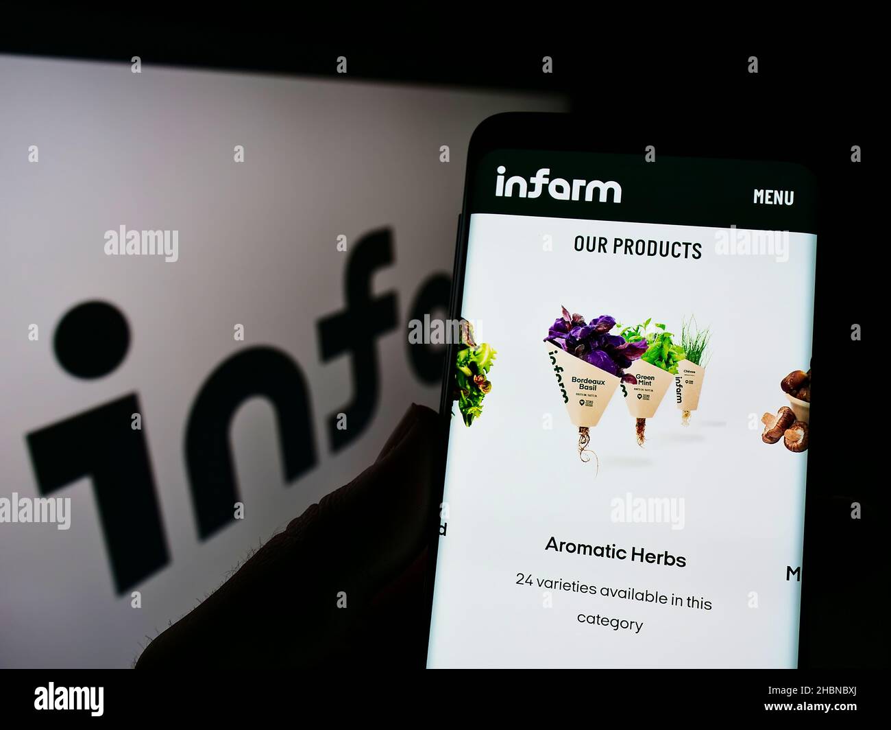 Person holding cellphone with webpage of German company infarm - Indoor ...