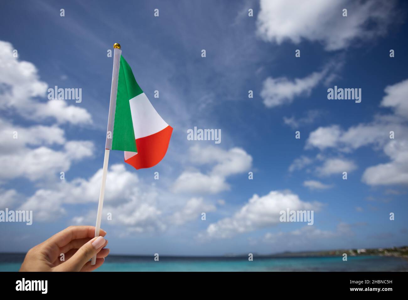Female hand holding Italian flag on the background of the seascape ...