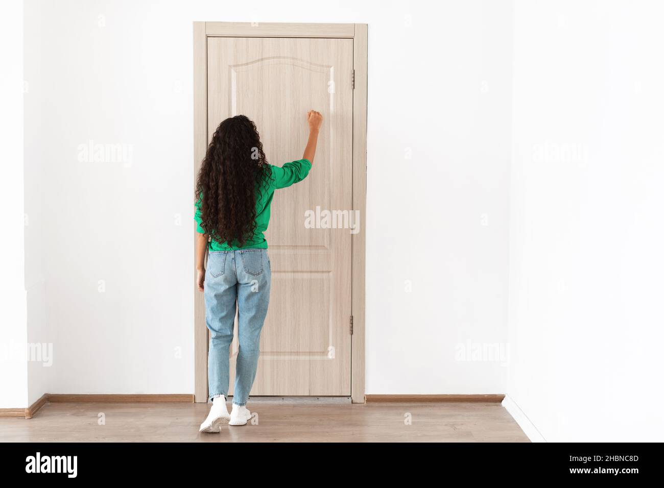 Woman at door knock back view hi-res stock photography and images - Alamy