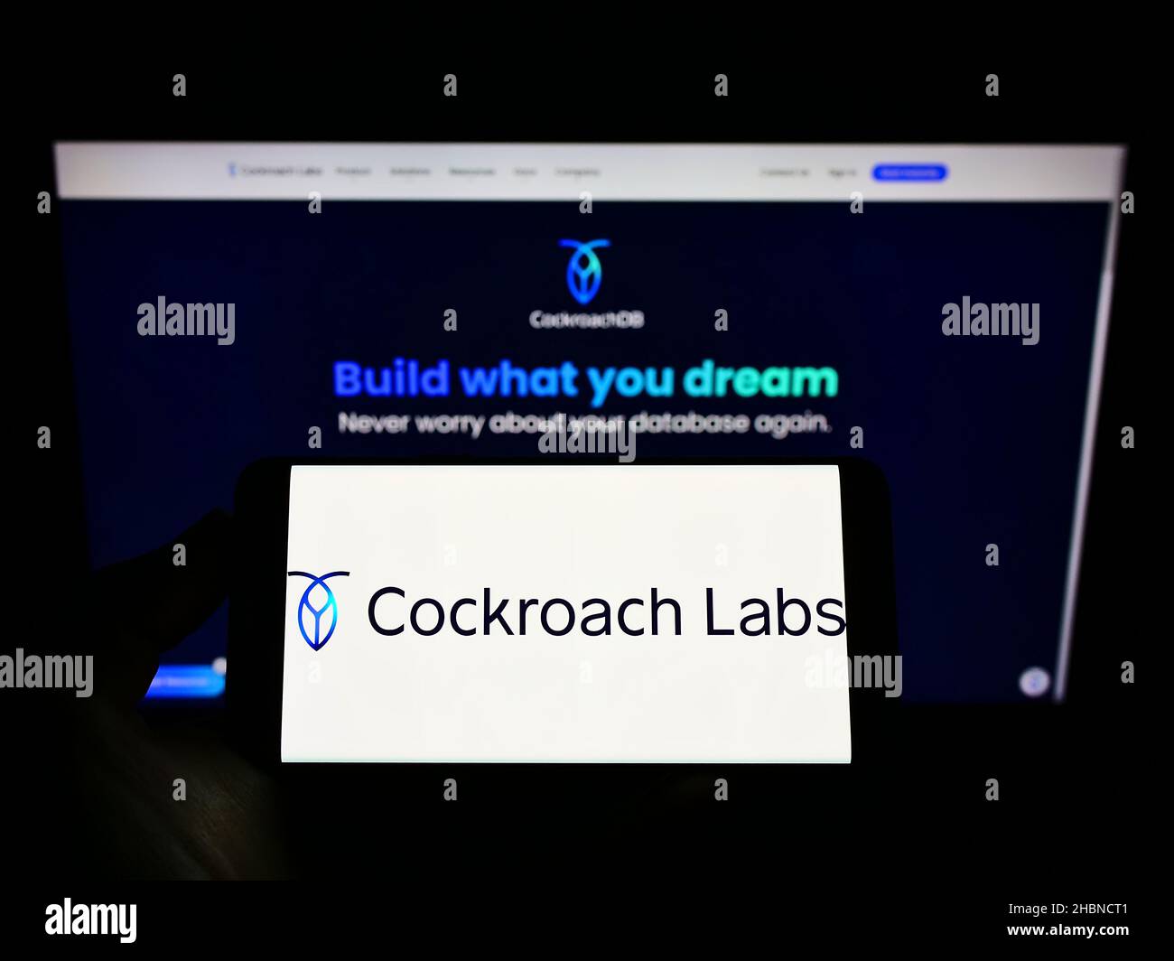 Person holding mobile phone with logo of American SQL database company ...