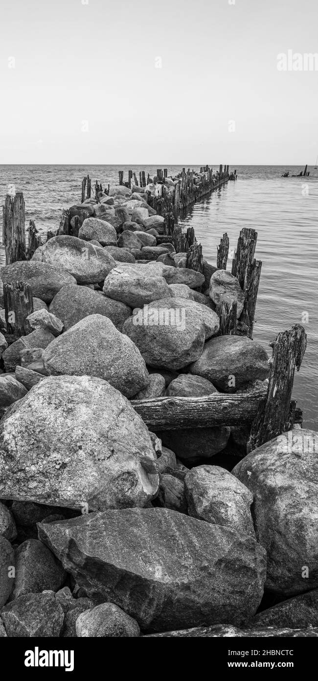 an old pier made of stones and wooden legs is left with metal screeds ...