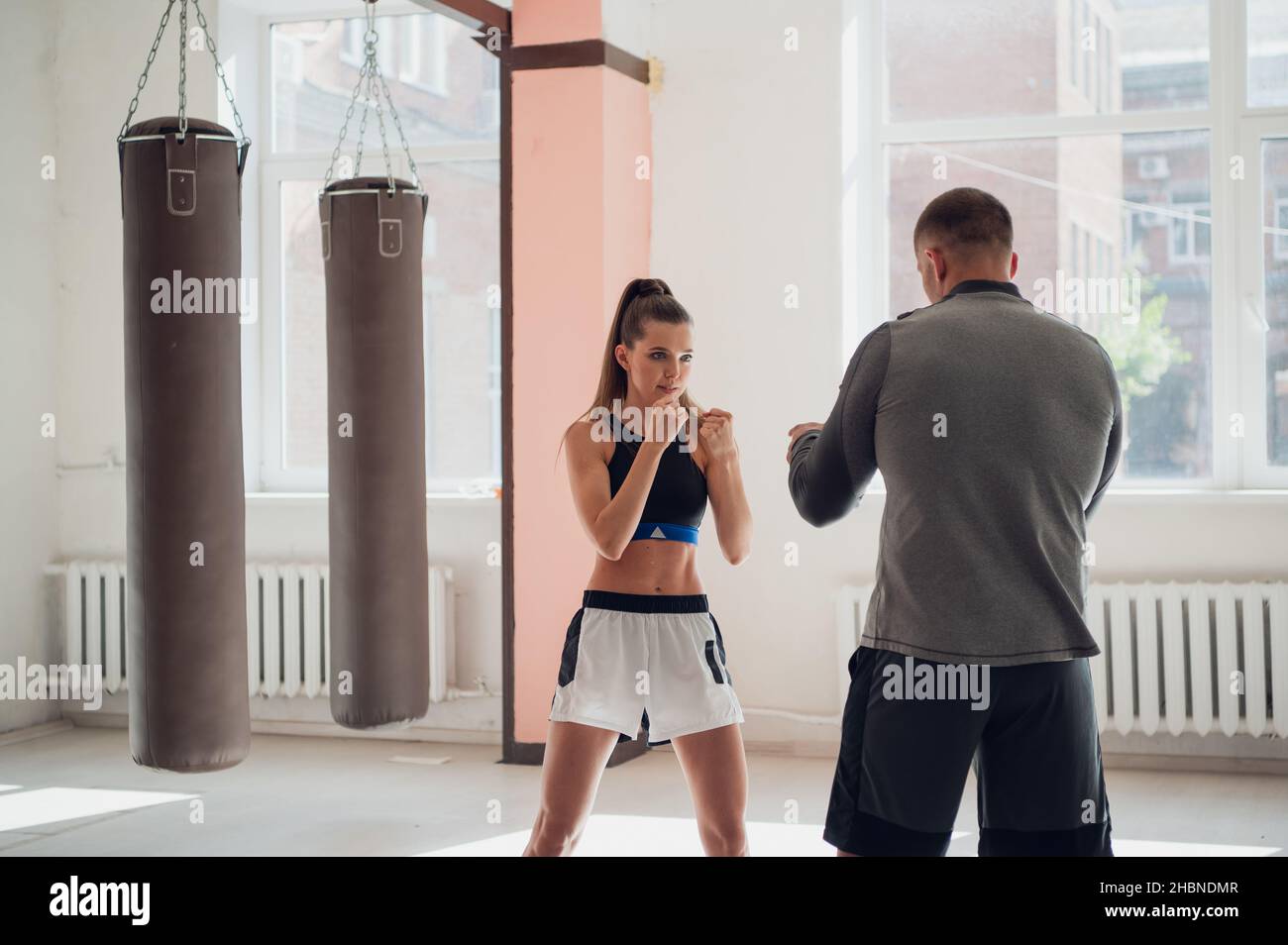Woman training boxing with personal trainer. Instructor teaching female ...