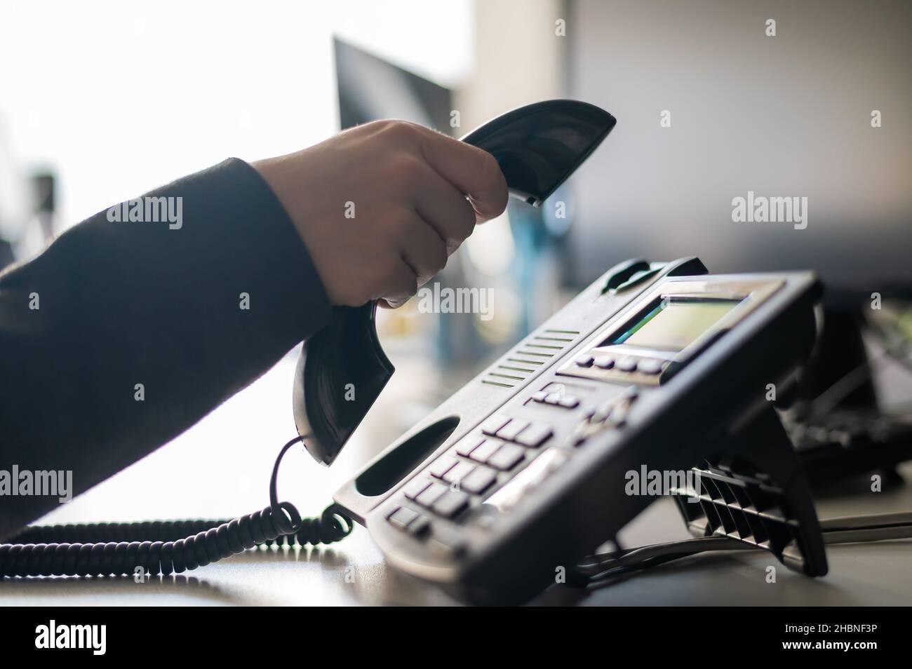 Close-up of the hand of a female office worker dialing a number on a ...