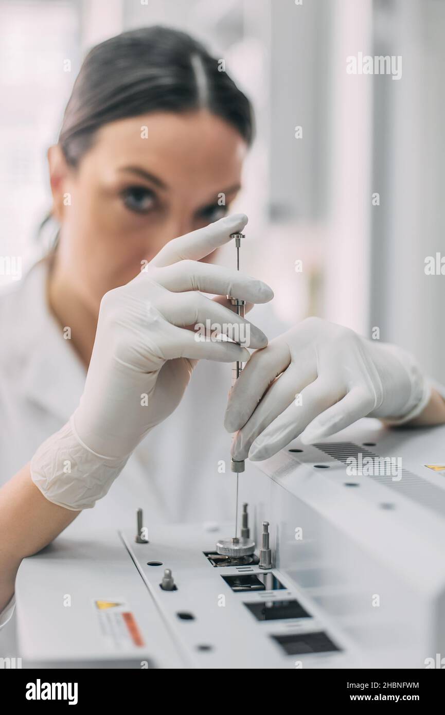 Portrait of female researcher doing research in a chemistry lab. Gas ...