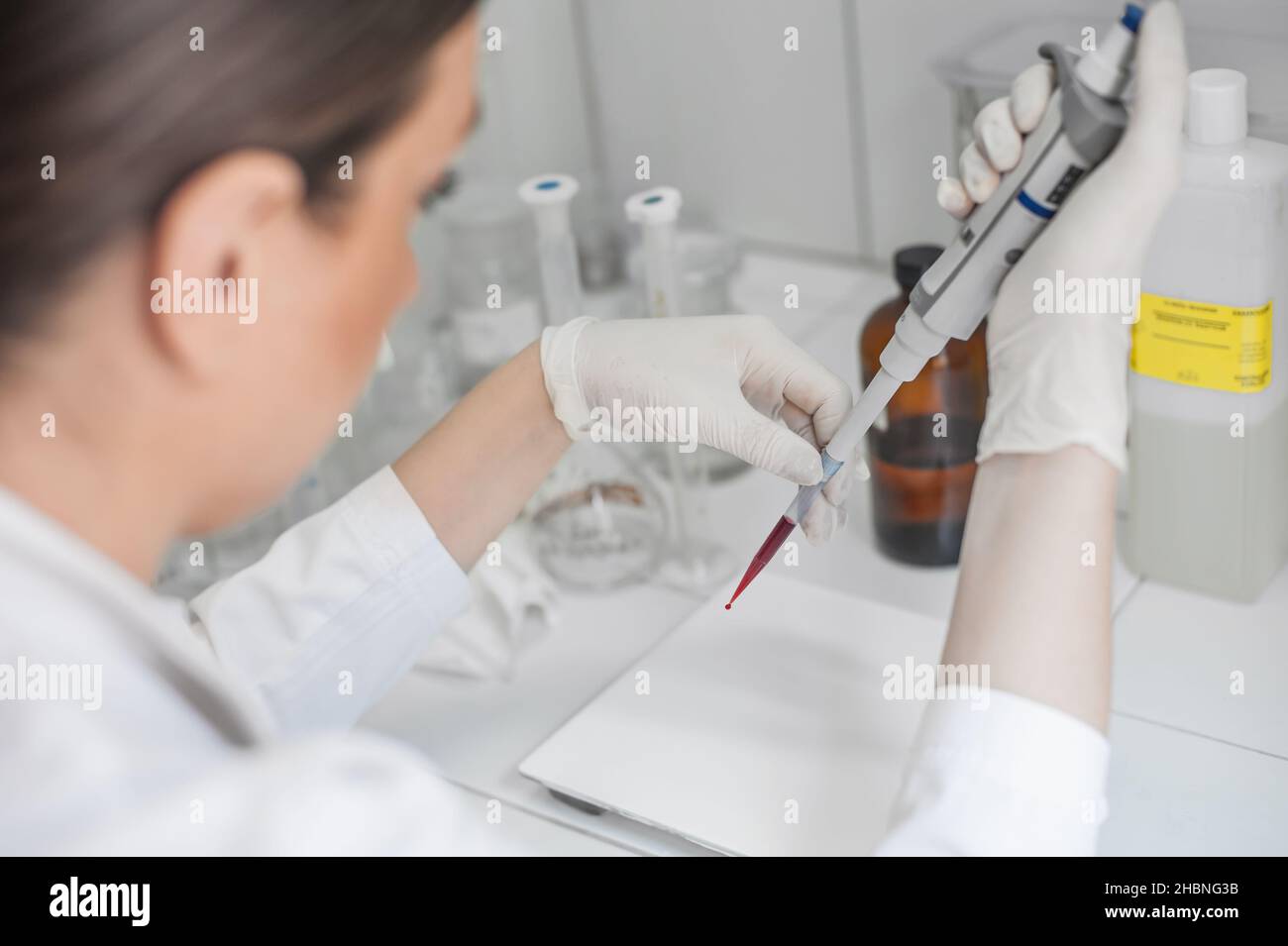 Medical laboratory scientists in the laboratory filling test tubes with ...