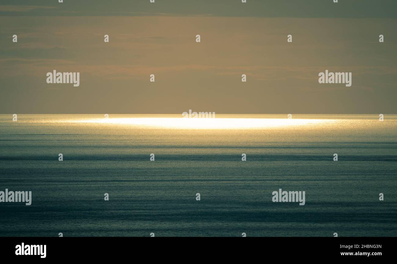 A breathtaking view of the sunset over the calm sea water surface Stock ...