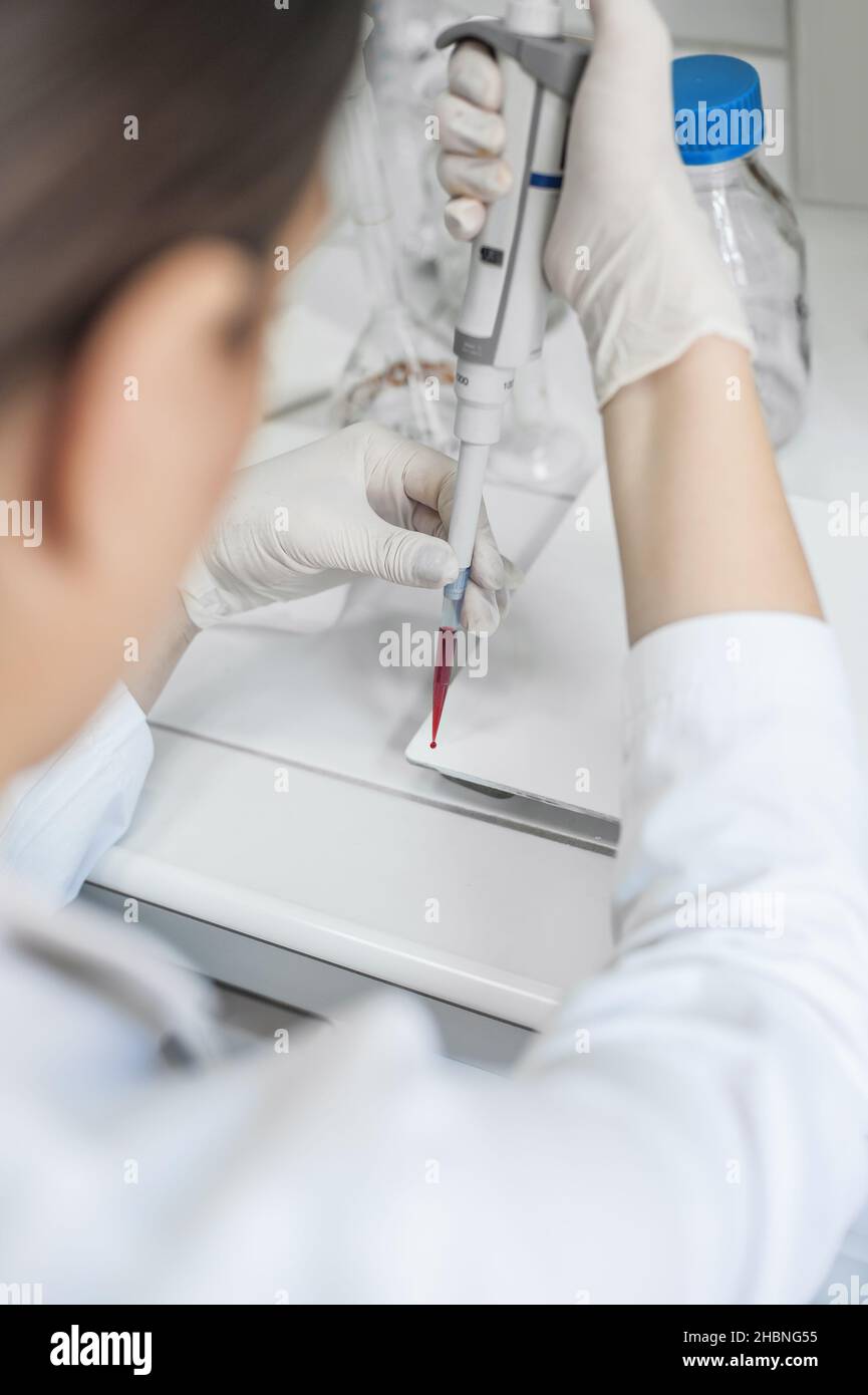Medical laboratory scientists in the laboratory filling test tubes with ...