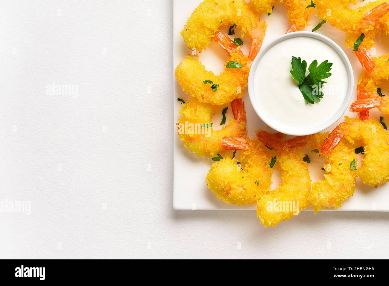 Deep fried breaded prawn on white plate over light stone background ...
